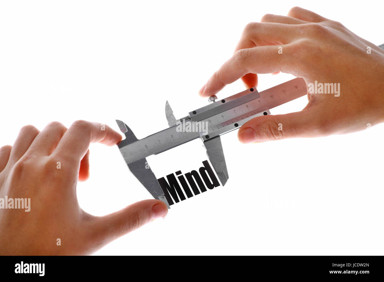 Two hands holding a caliper, measuring the word "Mind Stock Photo - Alamy