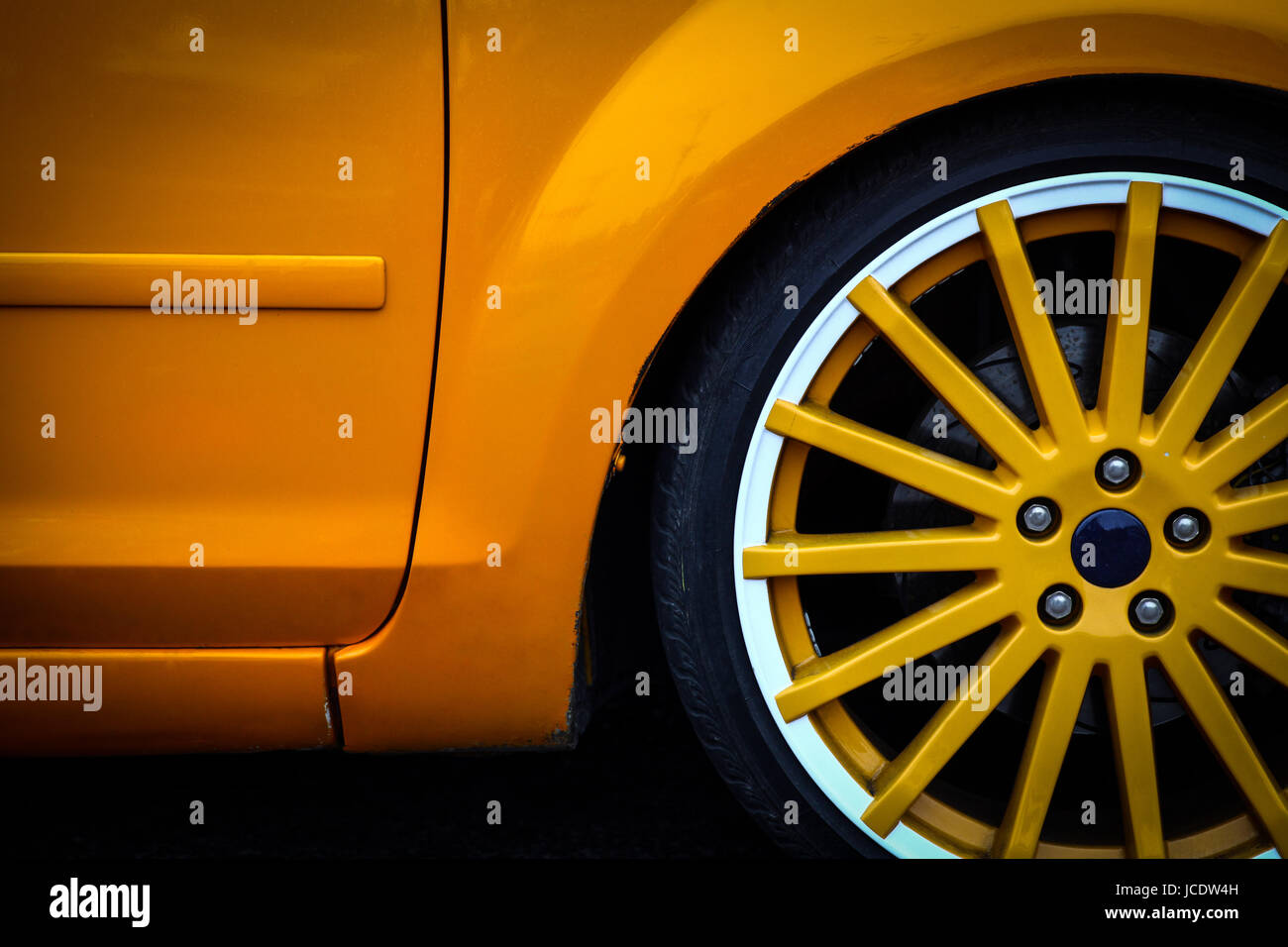 Detail of the front wheel of a yellow car Stock Photo - Alamy