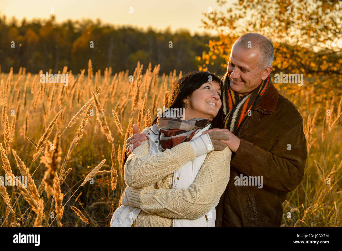 Couple in love embracing autumn sunset countryside looking each other ...