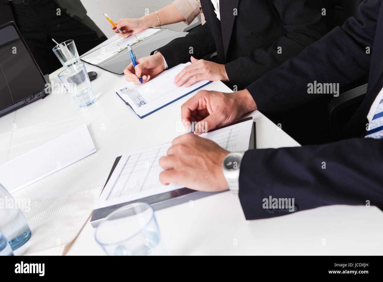 Team of business people taking notes at the meeting Stock Photo - Alamy