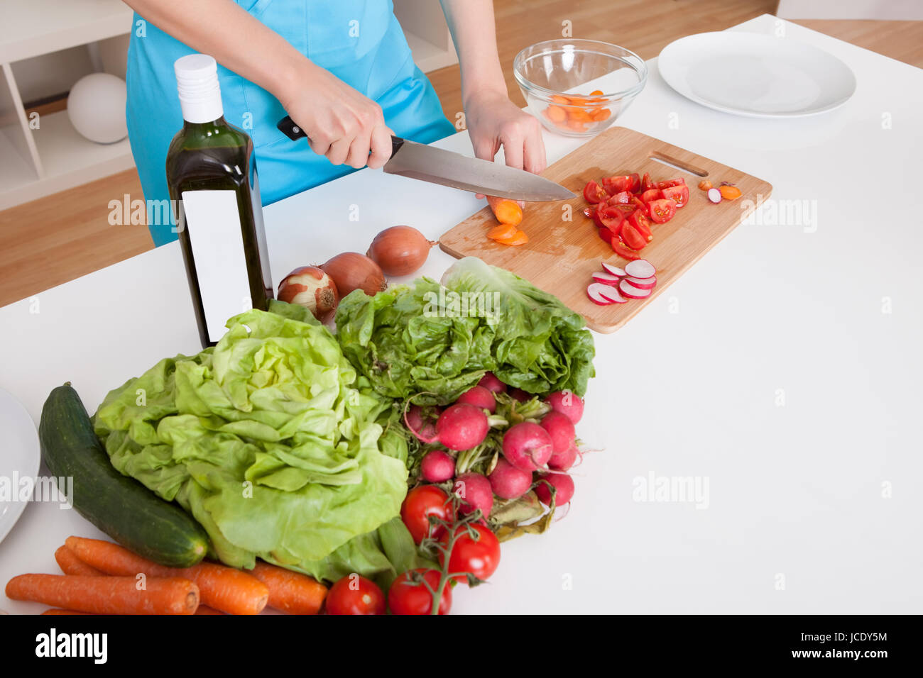 Cheerful young woman cooking in the kitchen Stock Photo - Alamy