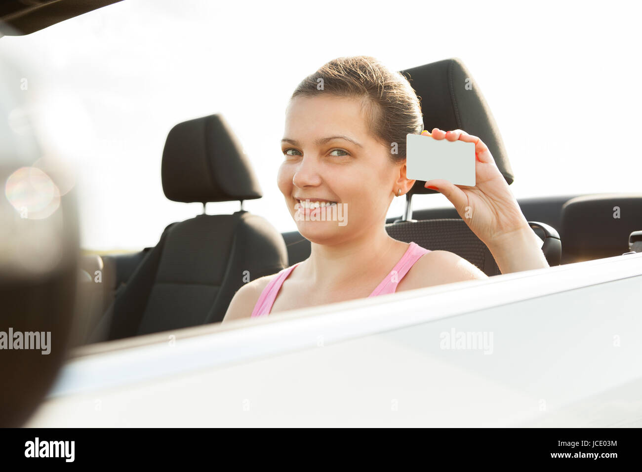 Happy Young Woman In Car Showing Driving License Stock Photo - Alamy