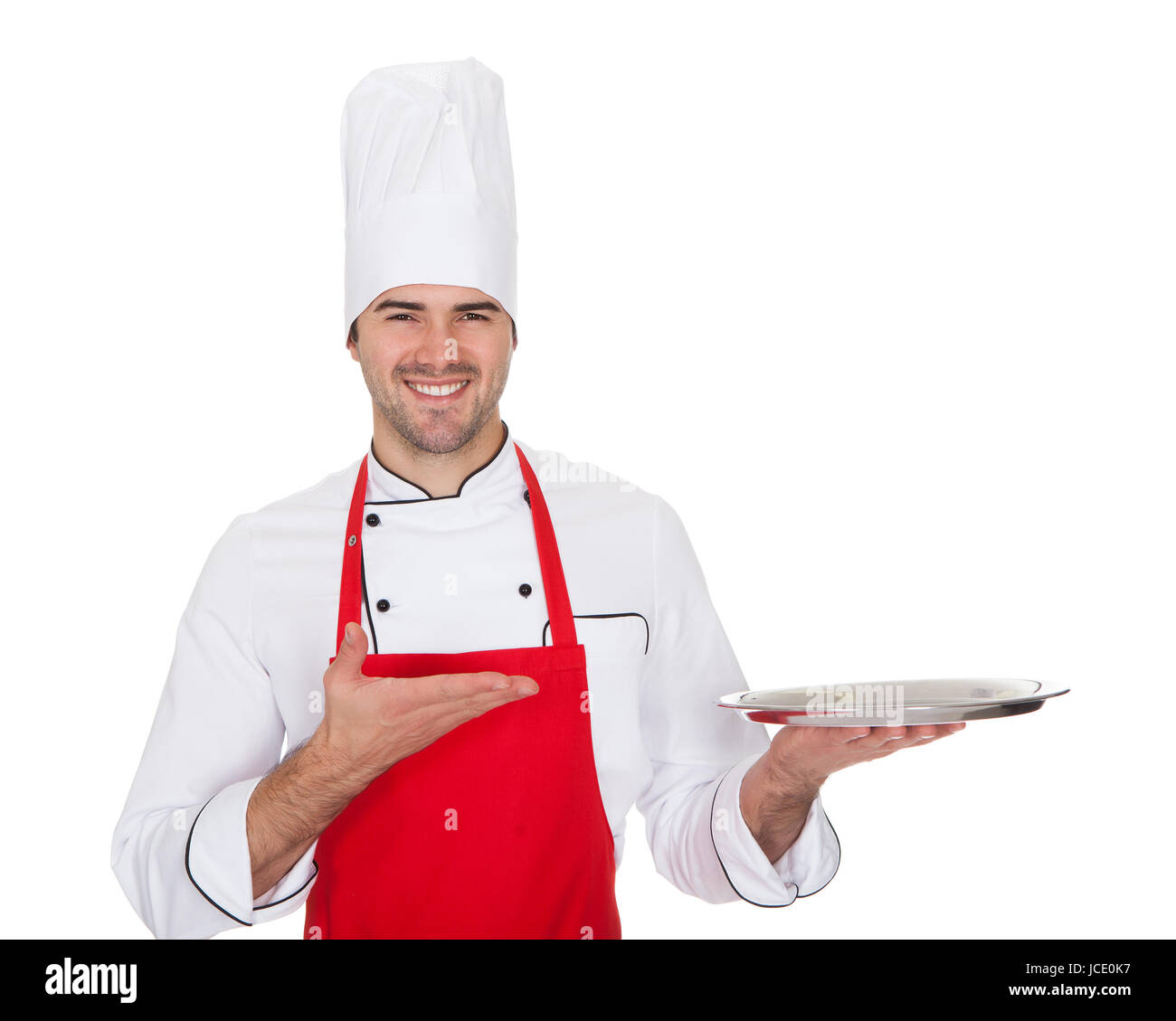 Portrait of cheerful chef presenting empty tray. Isolated on white ...