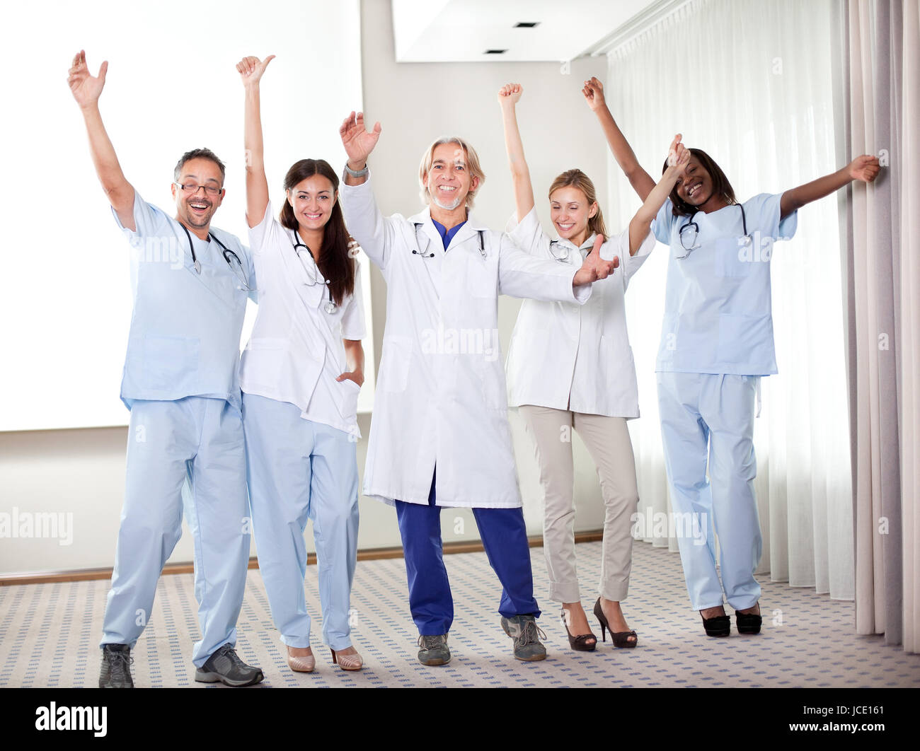 Group of happy doctors smiling and waving after a successful surgey at ...