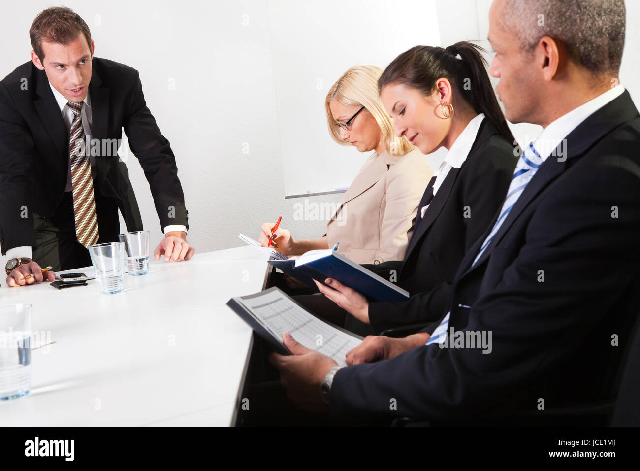 Team of business people taking notes at the meeting Stock Photo - Alamy