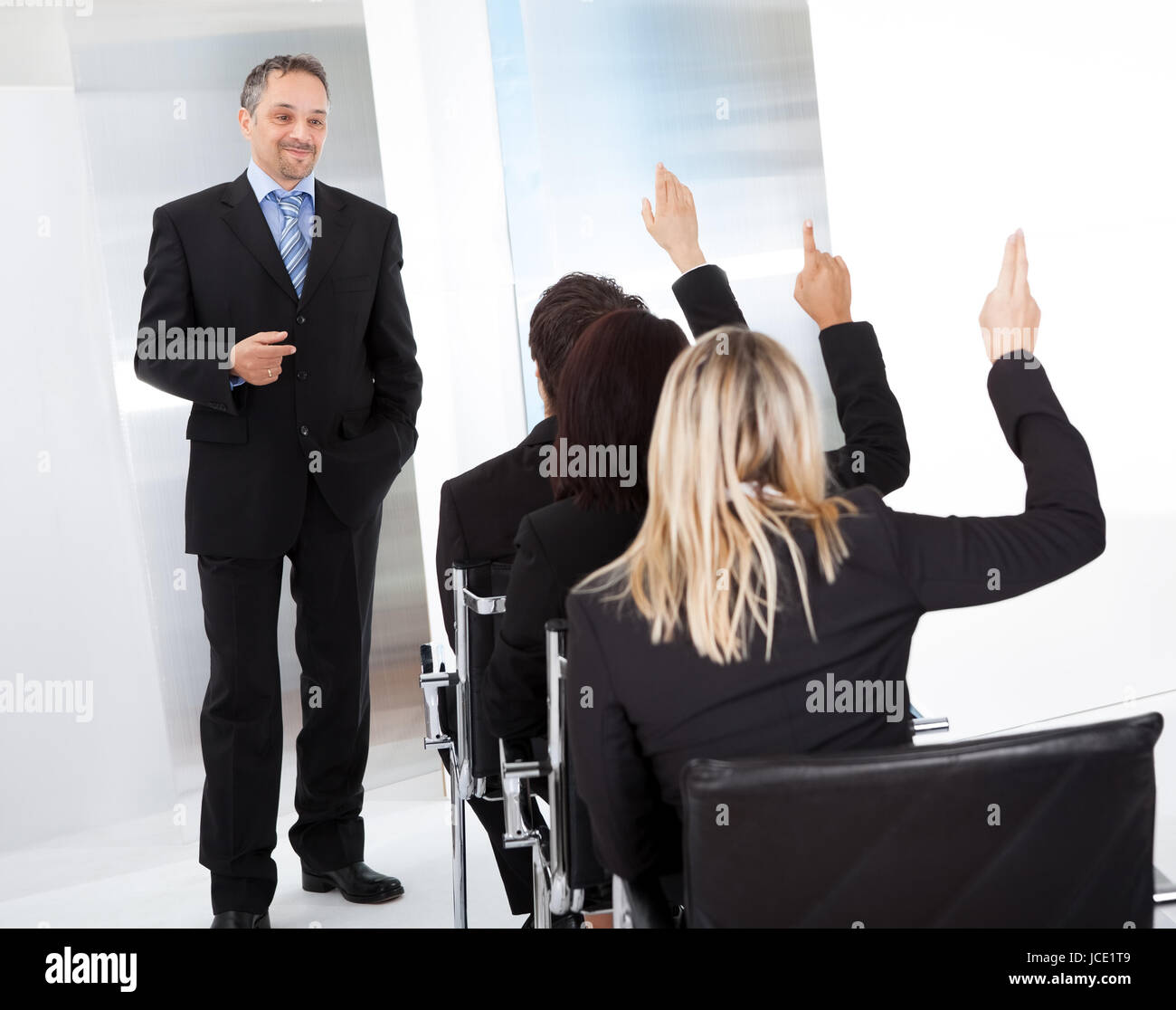 Group of successful business people at the lecture asking questions ...