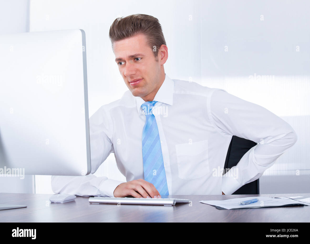 Businessman Using Computer Suffering From Back Ache Stock Photo - Alamy
