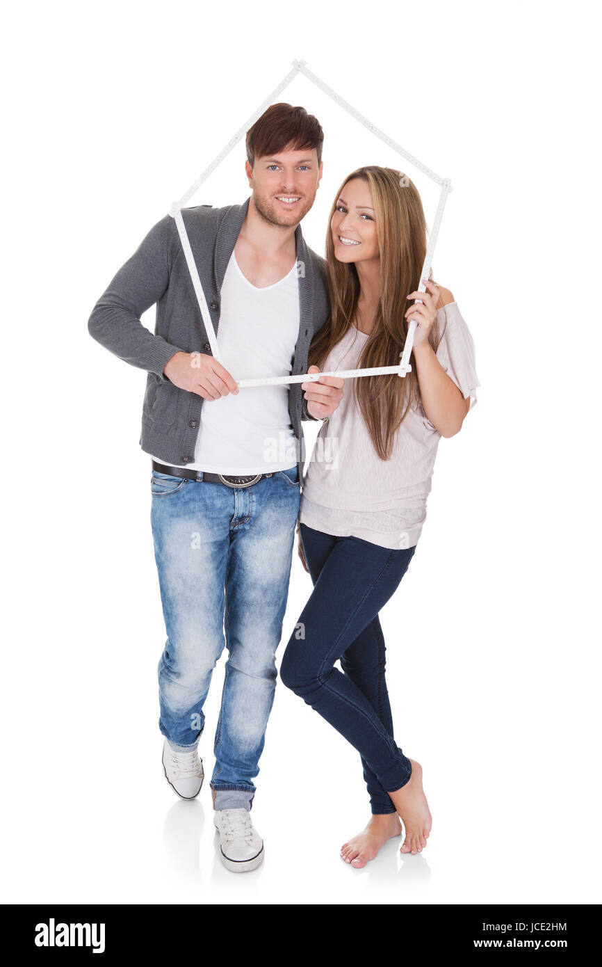 Smiling attractive young couple posing standing close together on a ...