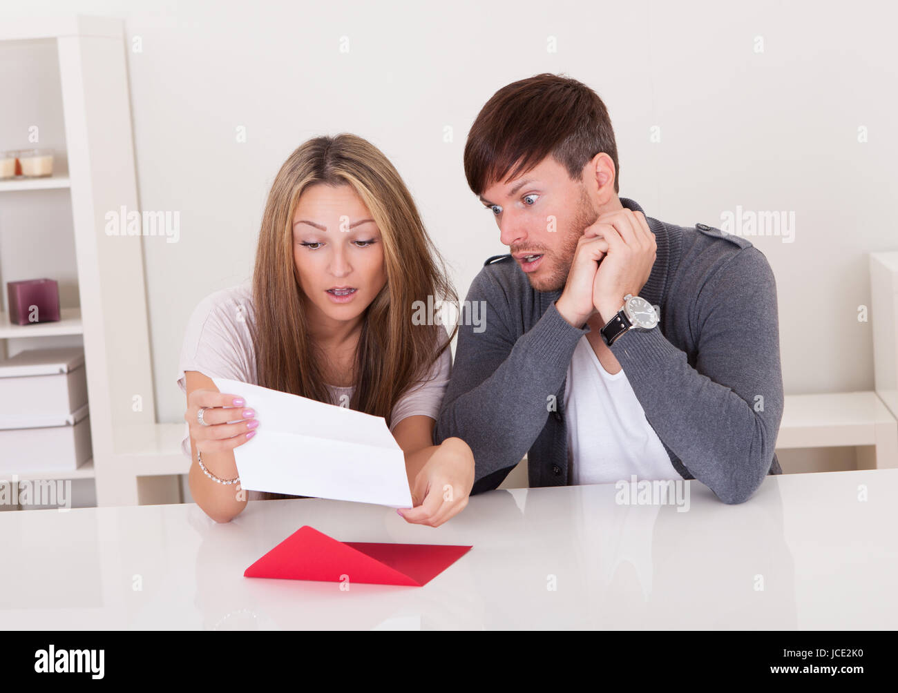 Shock portrayed on man's face after reading letter Stock Photo - Alamy