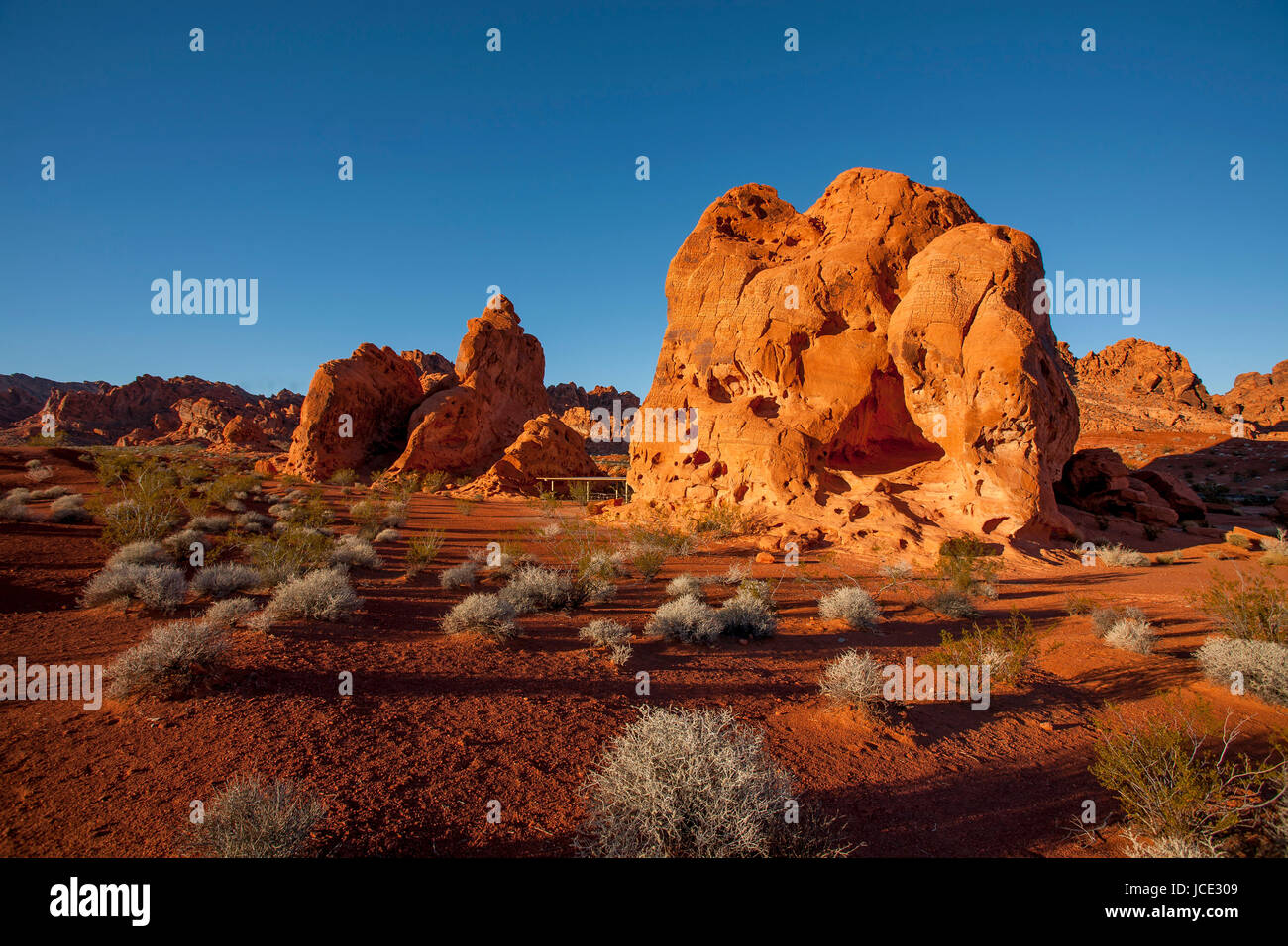 red rock formations in the desert lit by the sunset with blue skies in ...