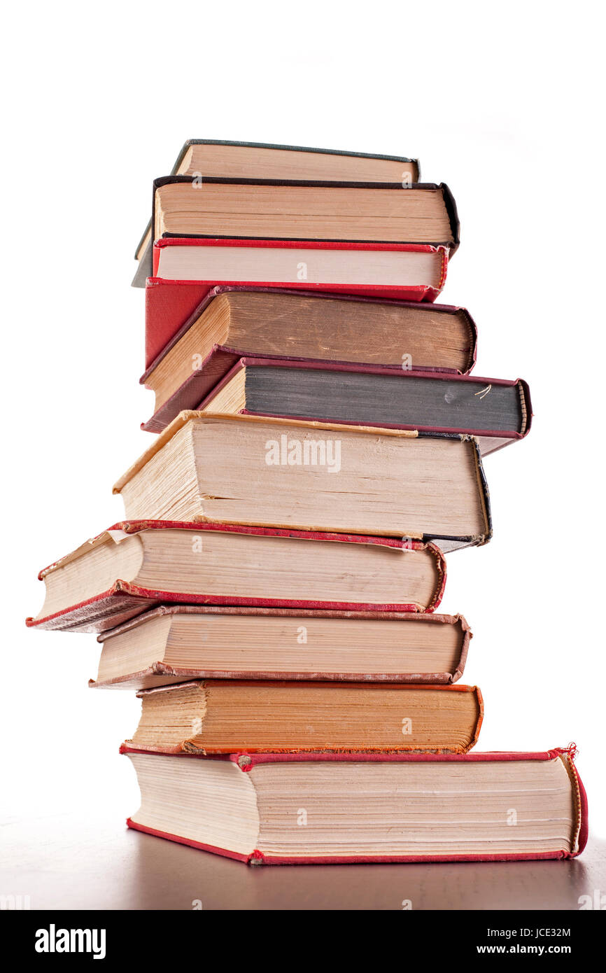 closeup of a stack of old books on tabletop isolated on white ...
