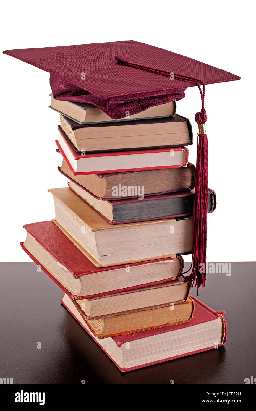 a stack of books on tabletop with a graduation cap on top Stock Photo ...