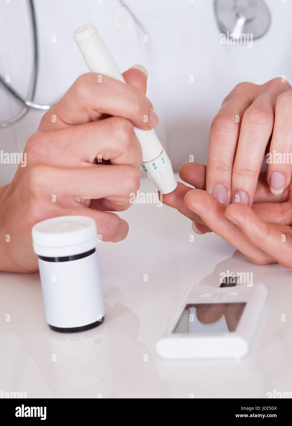 Doctor testing a patients glucose level after pricking his finger to ...