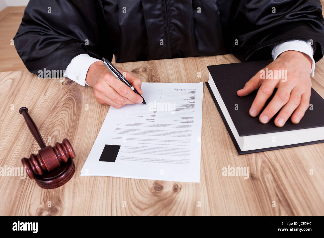 Male Judge Writing On Paper In Courtroom Stock Photo - Alamy