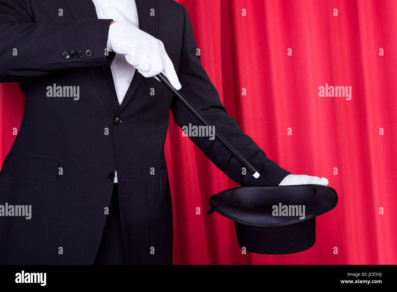 A Magician In A Black Suit Holding An Empty Top Hat And Magic Wand ...