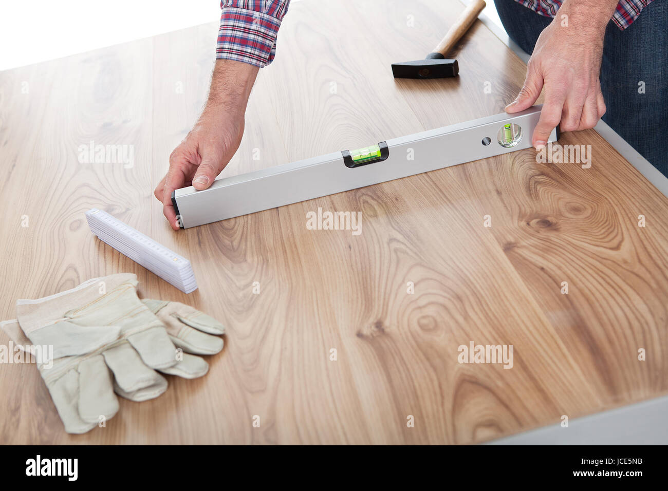 Worker measuring leveling of a laminate floor Stock Photo - Alamy