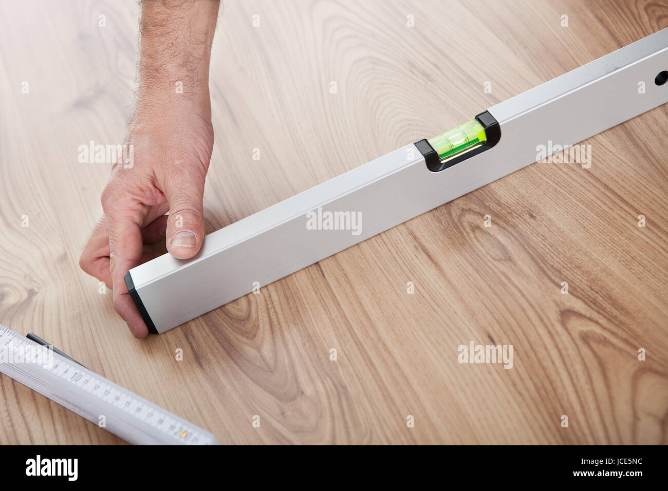 Worker measuring leveling of a laminate floor Stock Photo - Alamy