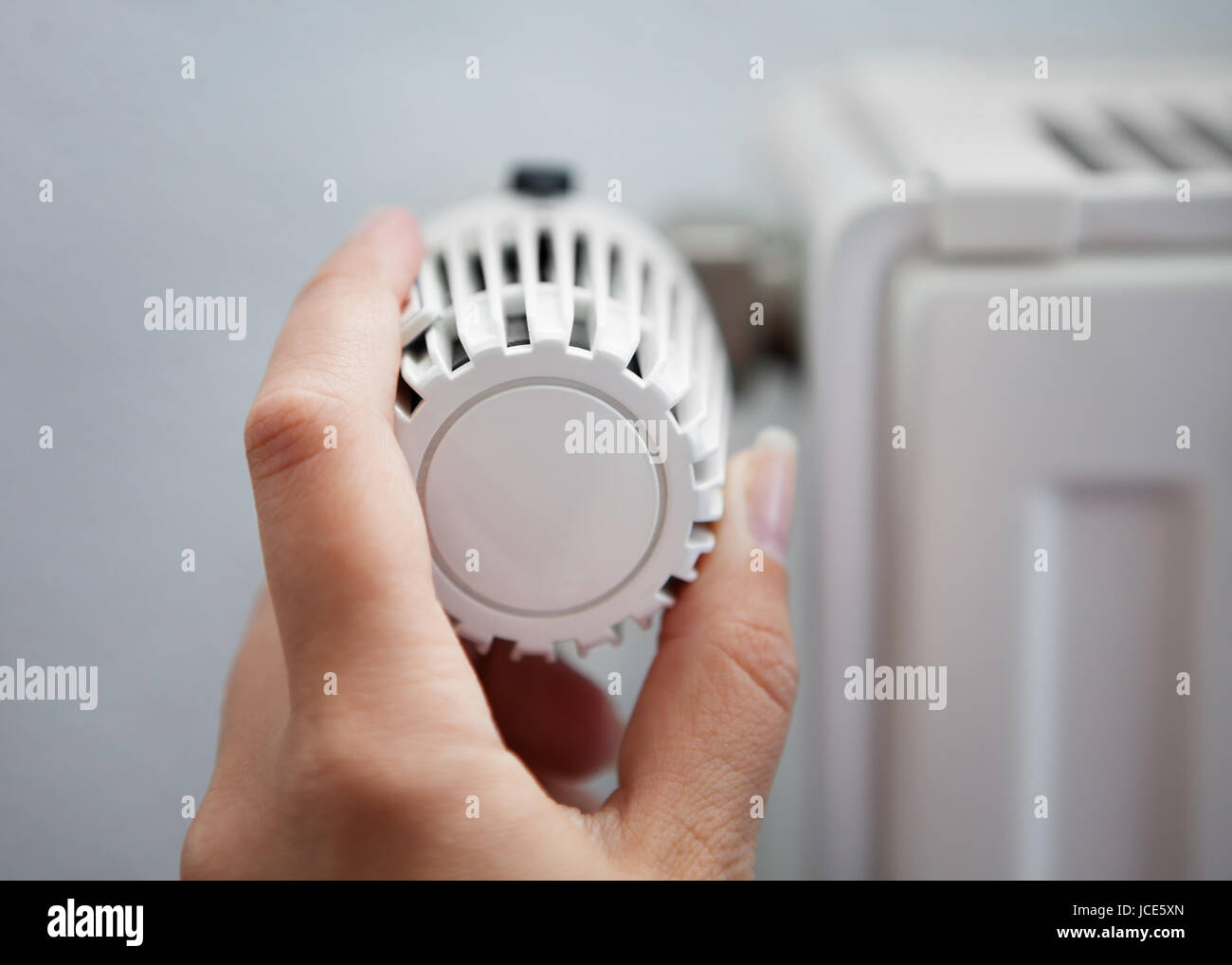 Woman Hand Adjusting The Temperature By Thermostat Stock Photo - Alamy