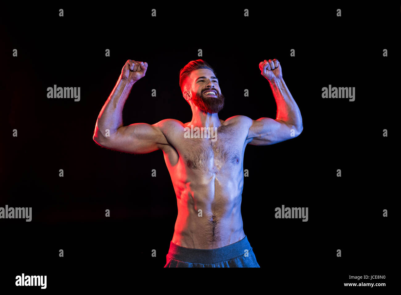 happy bodybuilder celebrating triumph isolated on black with dramatic ...