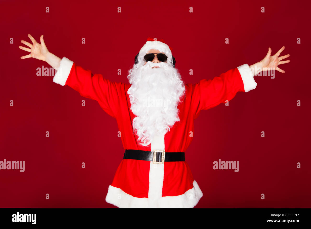 Portrait of excited santa raising his arms on red background Stock ...