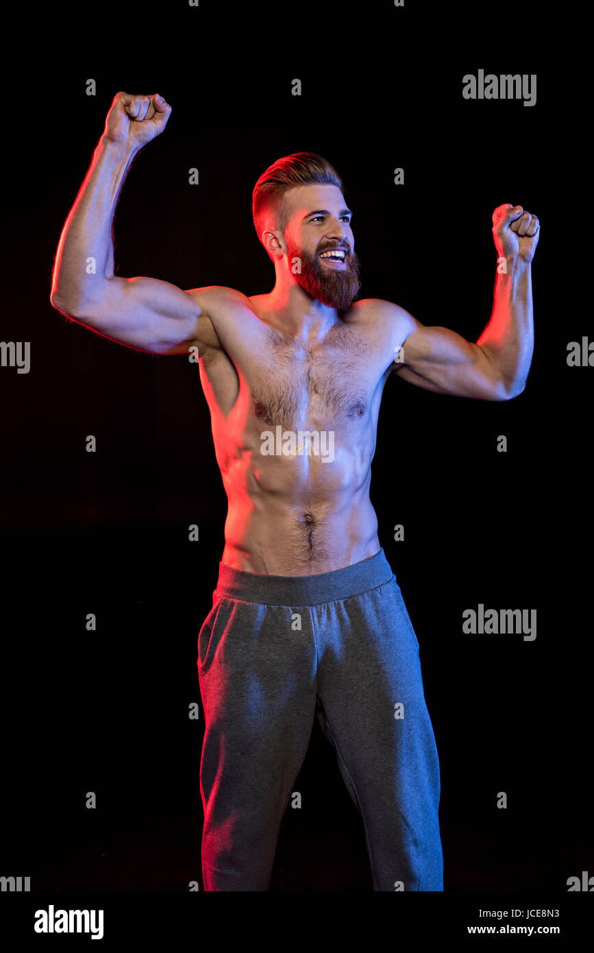 happy bodybuilder celebrating triumph isolated on black with dramatic ...