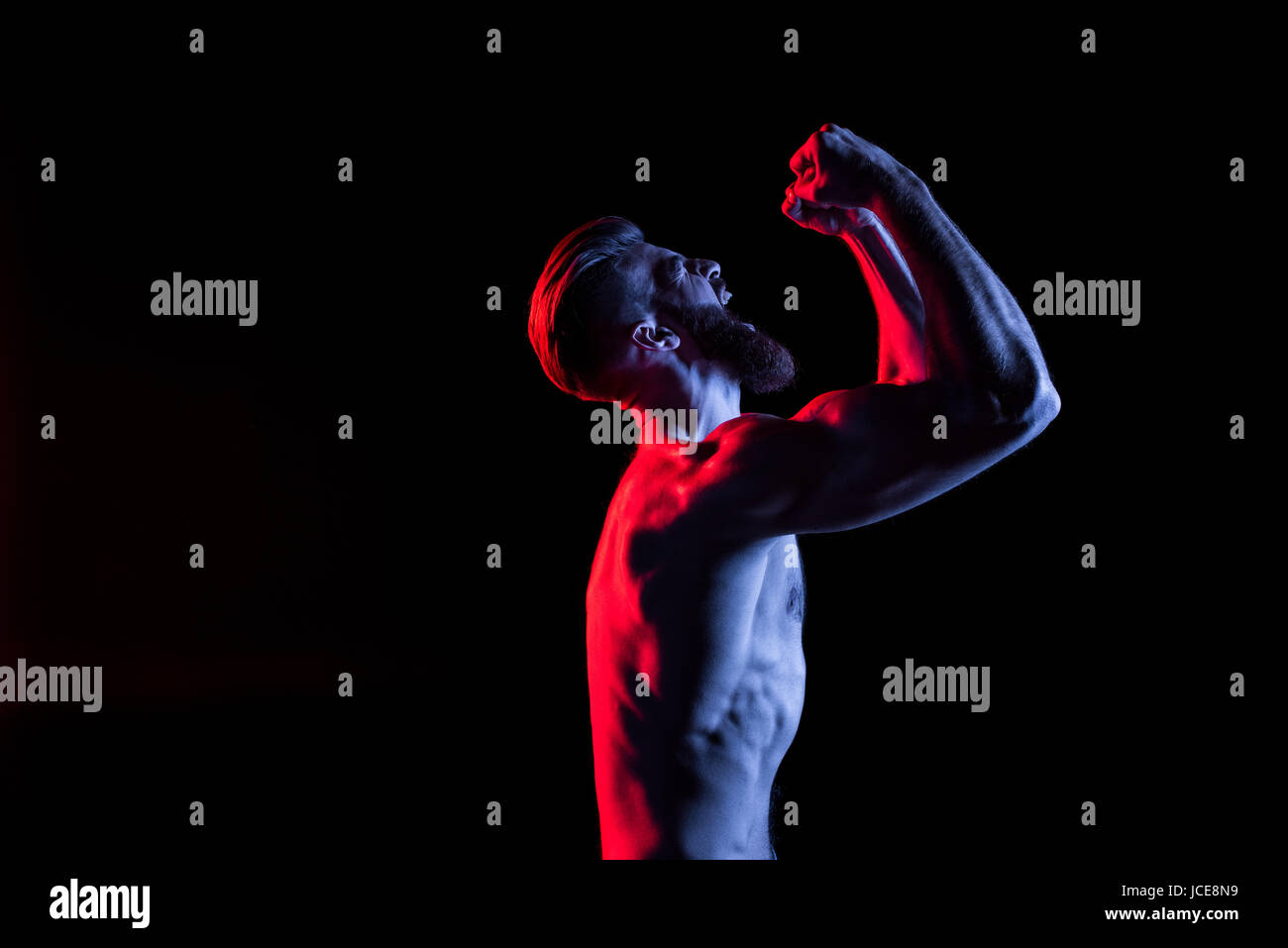 handsome bodybuilder gesturing and yelling isolated on black with ...