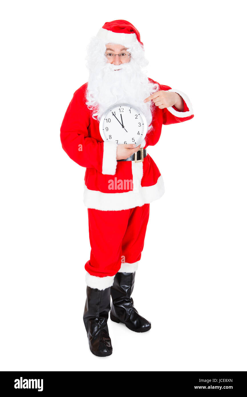 Santa Pointing At Clock Showing Time Over White Background Stock Photo ...