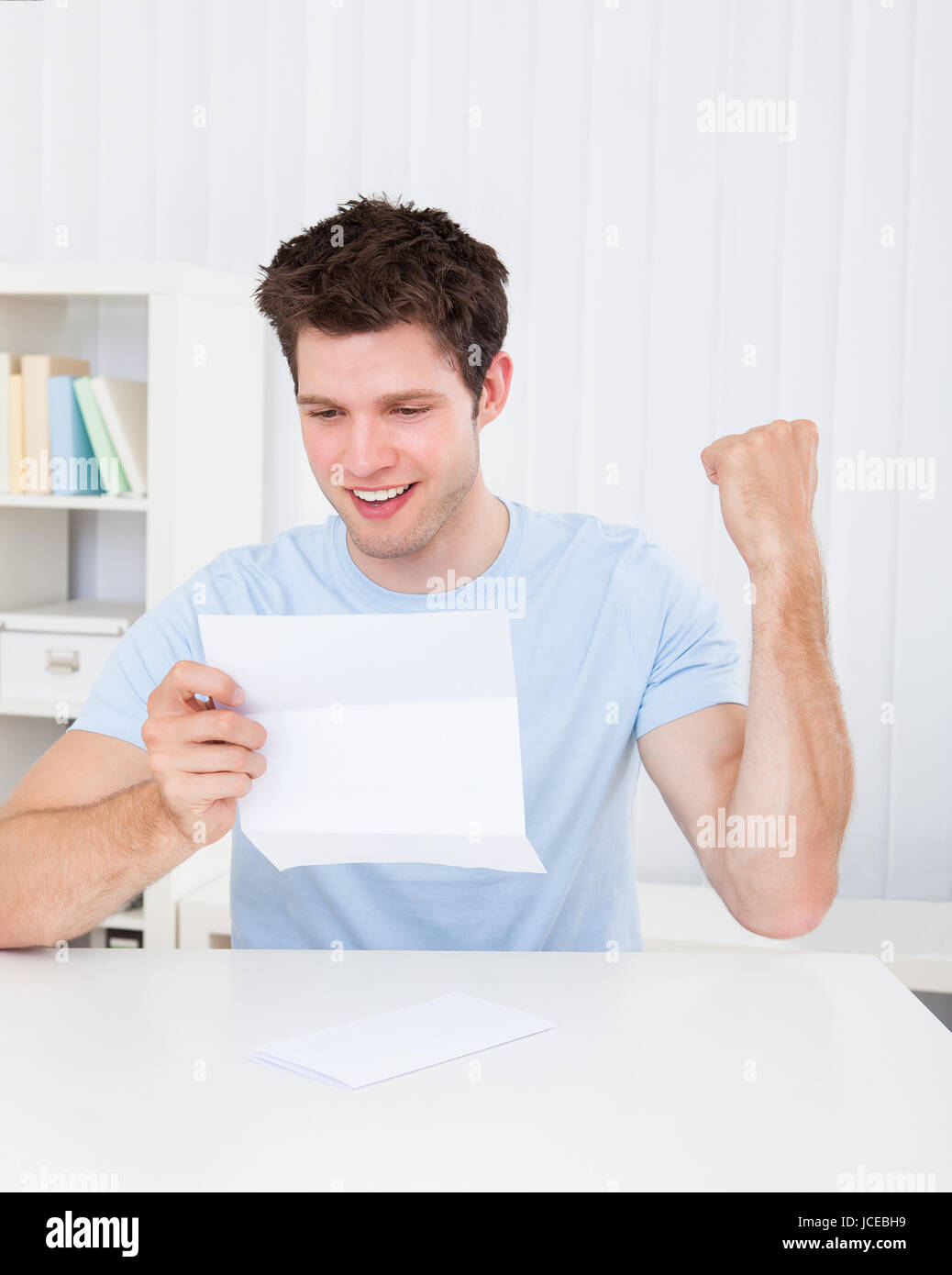 Happy Young Man Reading Paper Holding In Hands Stock Photo - Alamy