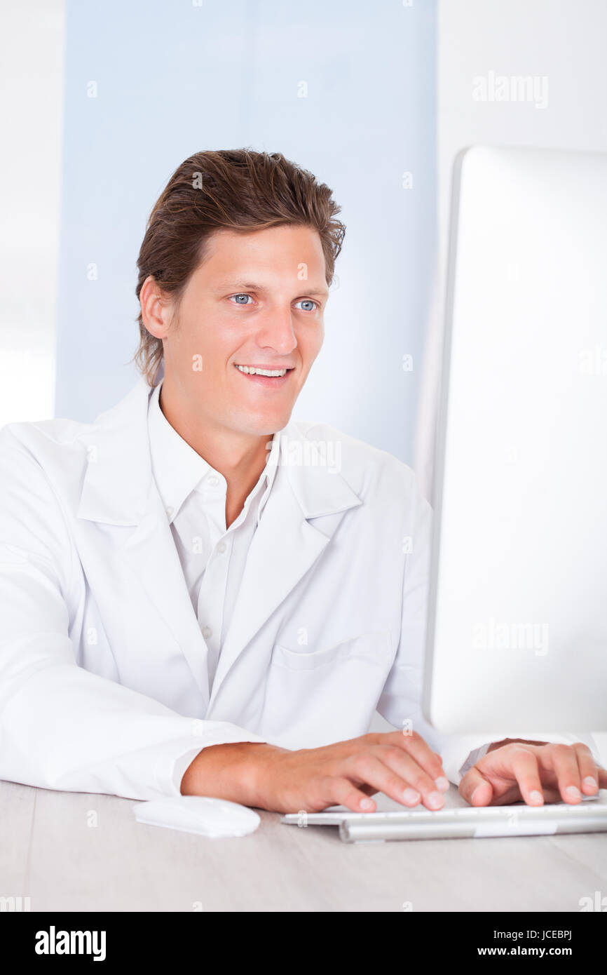 Portrait Of Happy Male Doctor Typing On Keyboard Stock Photo - Alamy
