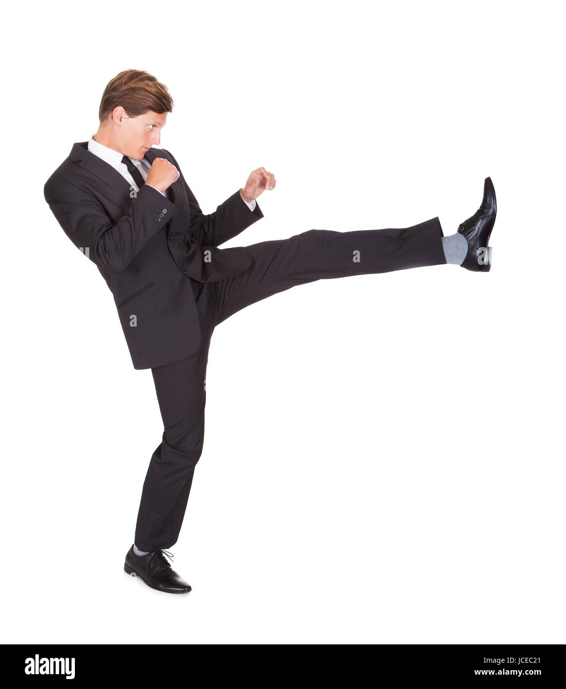 Young Man In Black Suit Kicking On White Background Stock Photo - Alamy