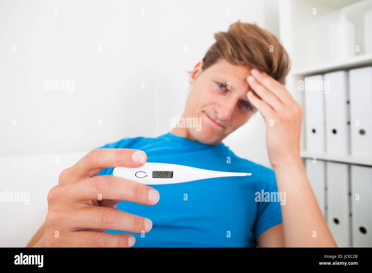 Man Suffering From Fever And Measuring Temperature With Thermometer ...