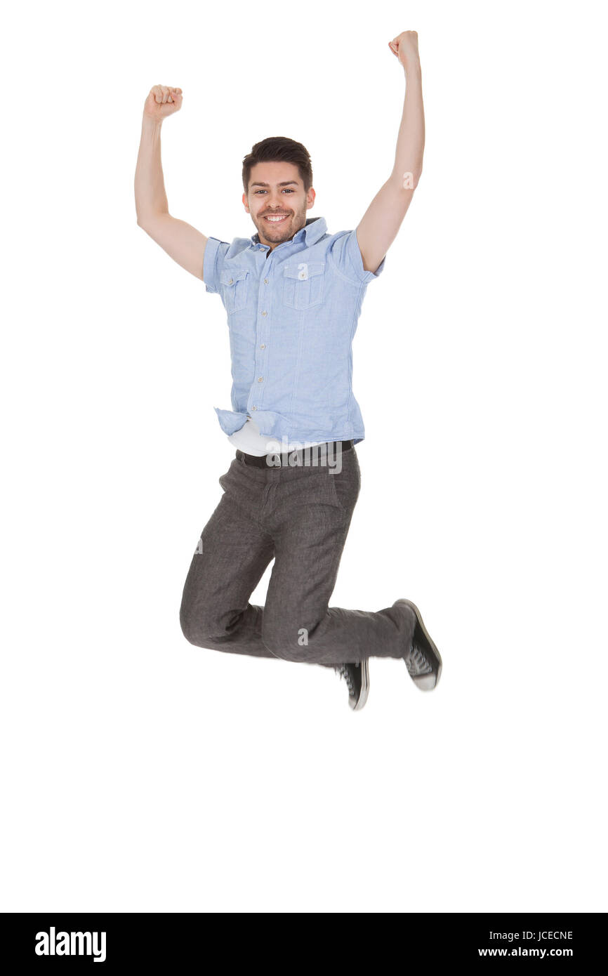 Young Man Jumping With Arms Raised Over White Background Stock Photo ...