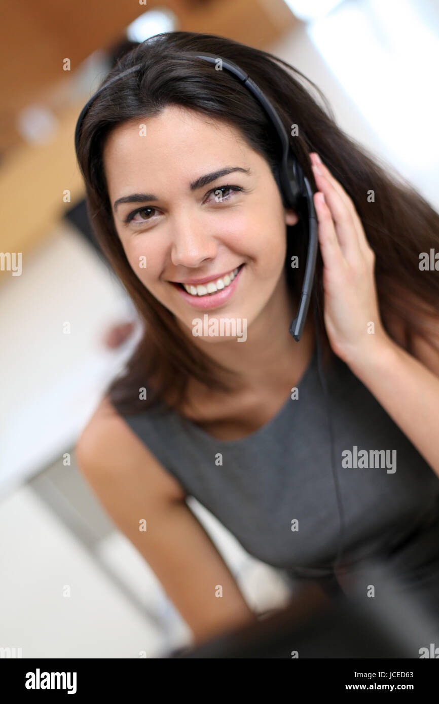 Portrait of smiling receptionist with headphones Stock Photo - Alamy