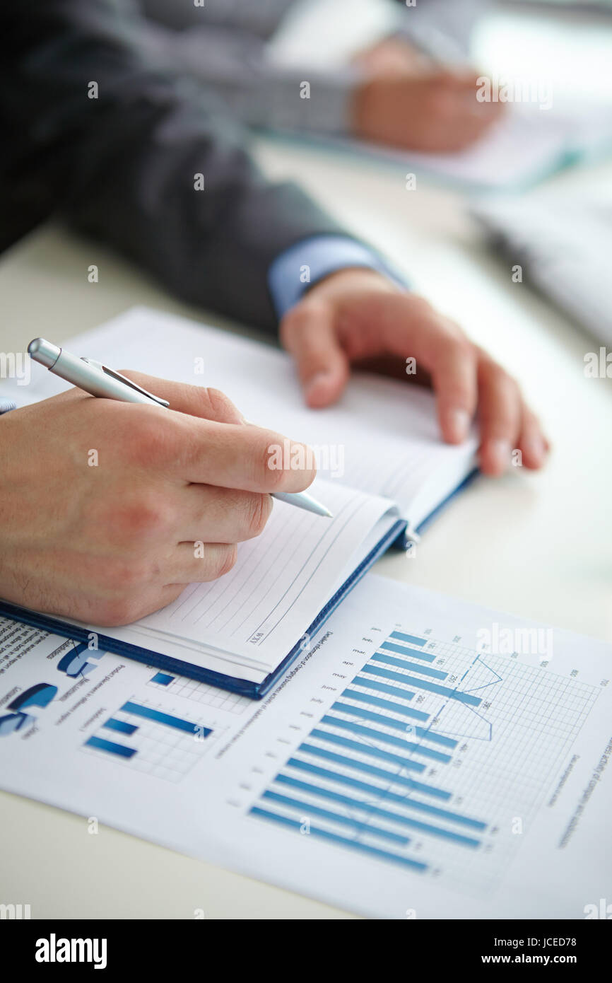 Businessman hand with pen over open notebook making report Stock Photo ...