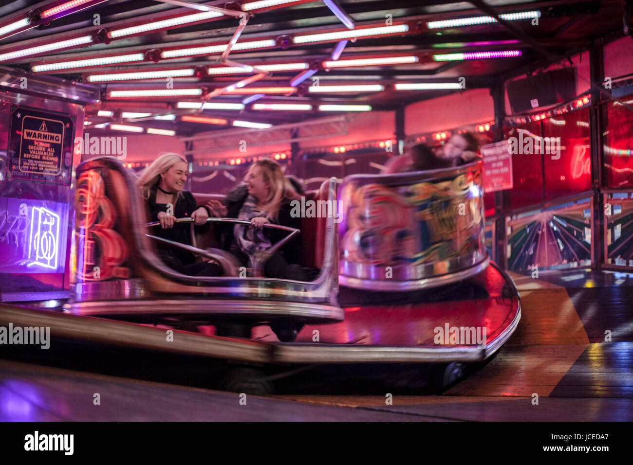 Funfairs, rides, and amusement parks. 2 girls riding on a waltzer Stock ...