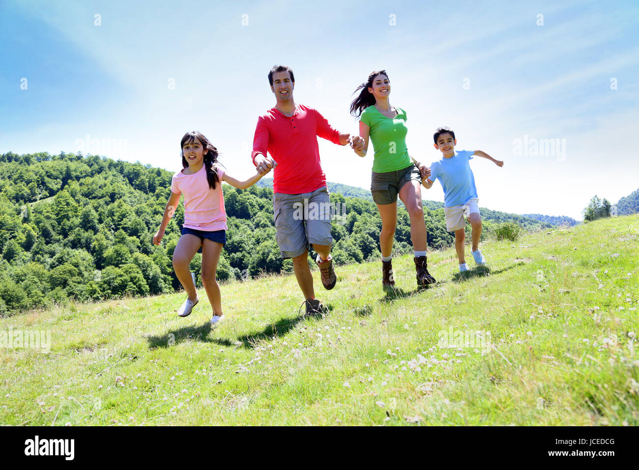Happy family enjoying and running together in the mountains Stock Photo ...