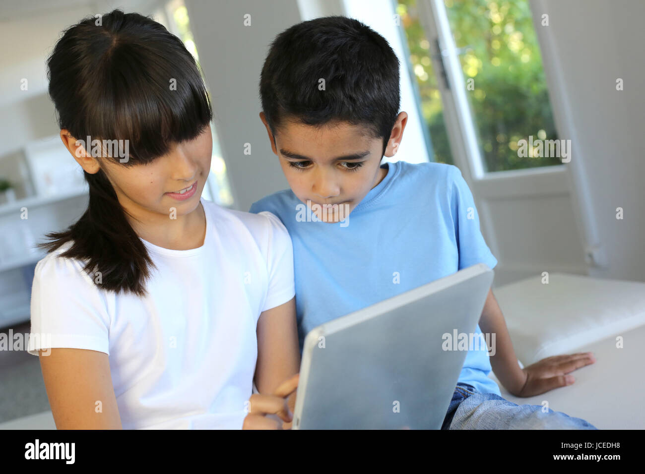 Children playing with electronic tablet at home Stock Photo - Alamy