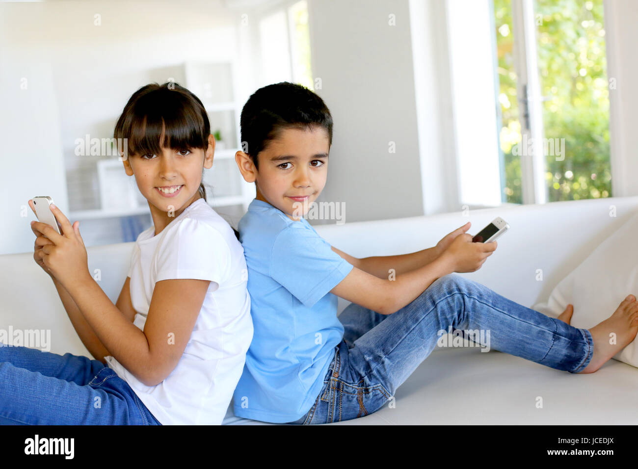 Kids playing at home with smartphones Stock Photo - Alamy