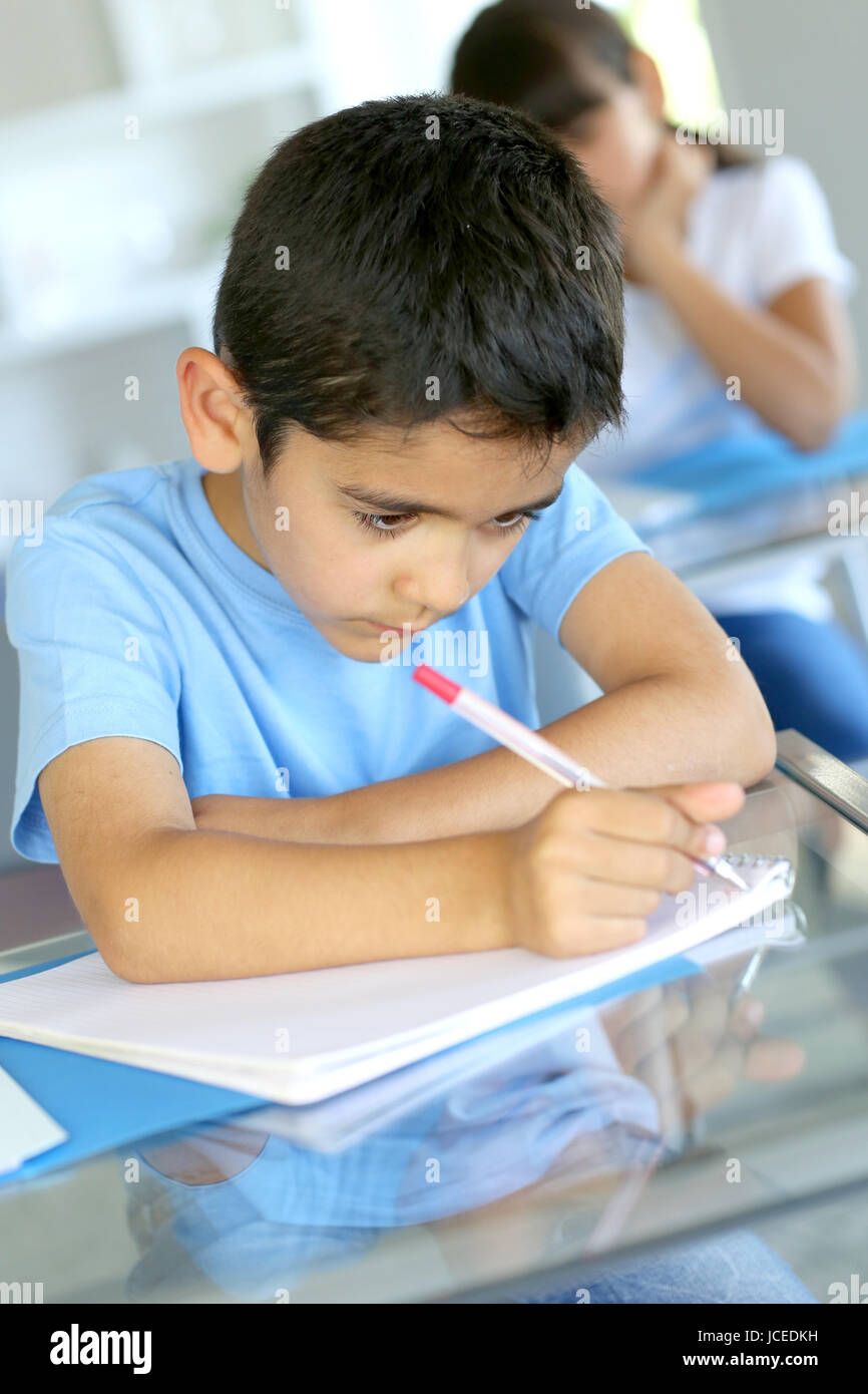 Closeup of young boy writing on notebook at school Stock Photo - Alamy