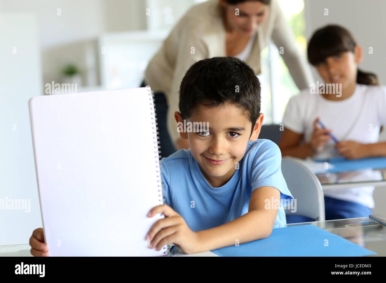 Portrait of cute little boy showing notebook towards camera Stock Photo ...