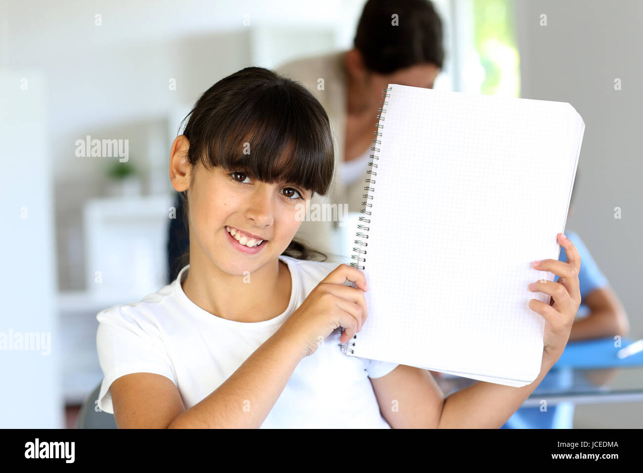 Closeup of beautiful school girl showing notebook page Stock Photo - Alamy