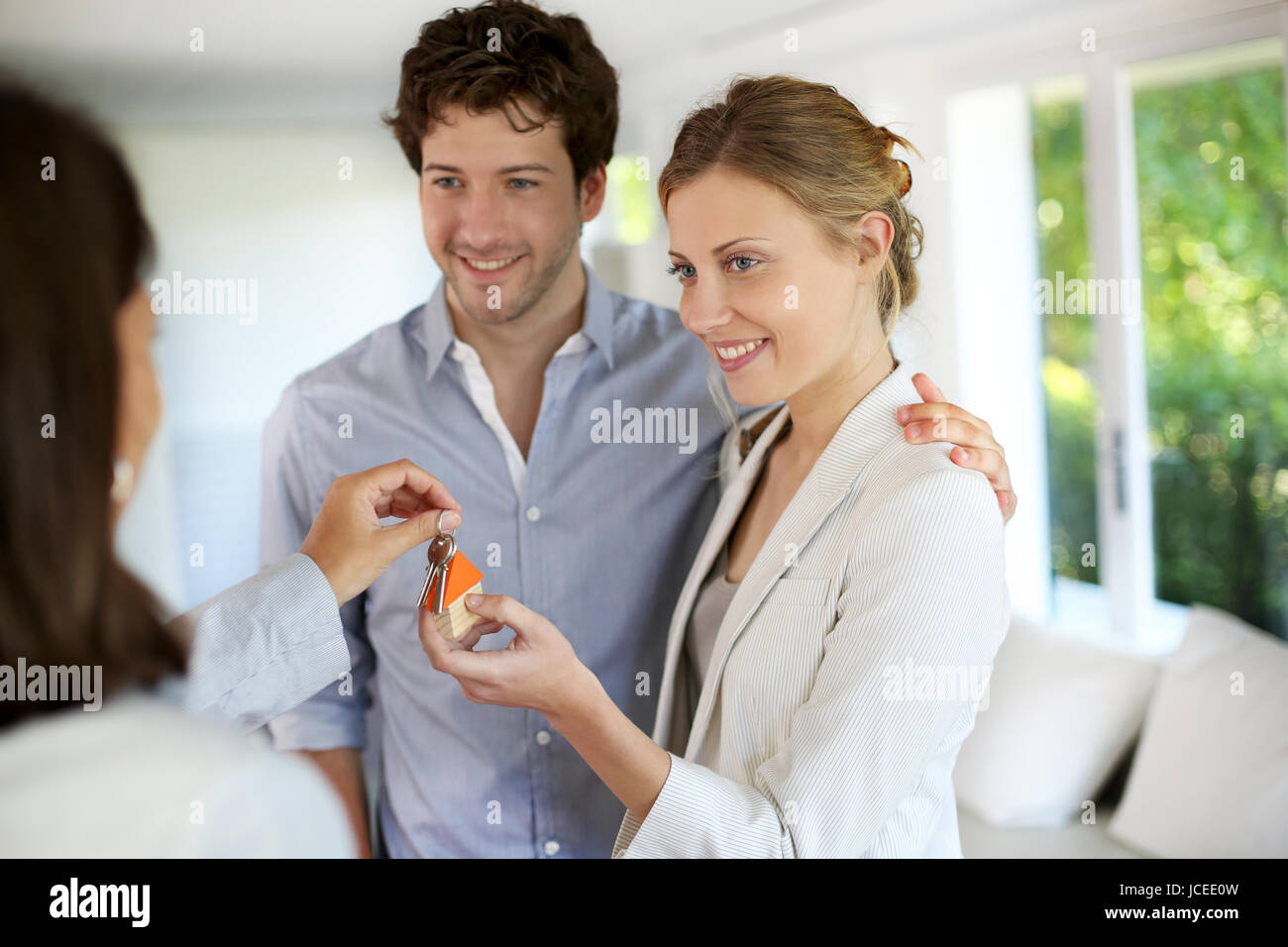 Happy young couple getting keys of their new home Stock Photo - Alamy