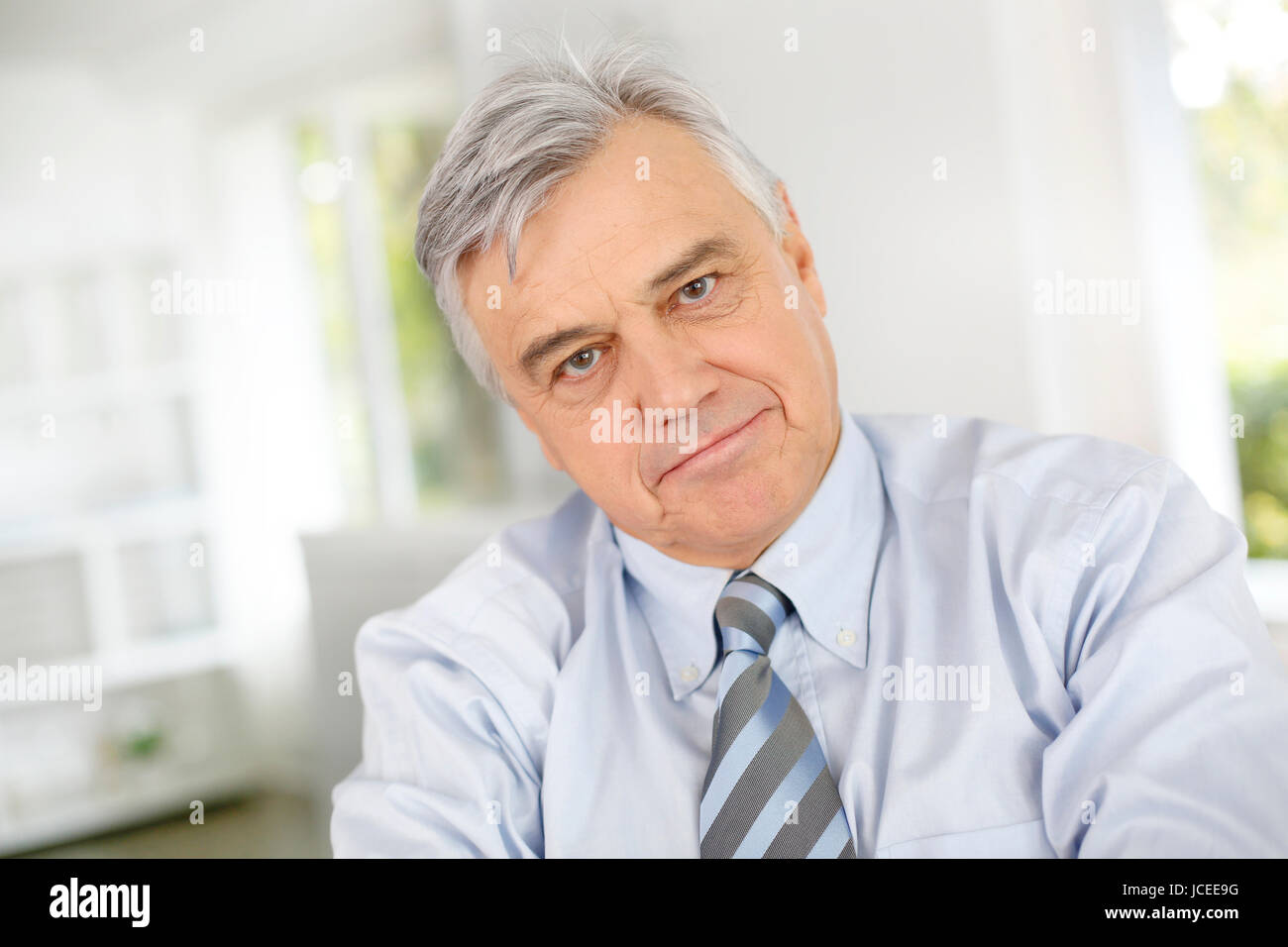 Portrait of senior businessman with serious look Stock Photo - Alamy