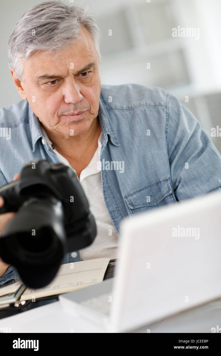 Senior reporter working in office in front of laptop Stock Photo - Alamy