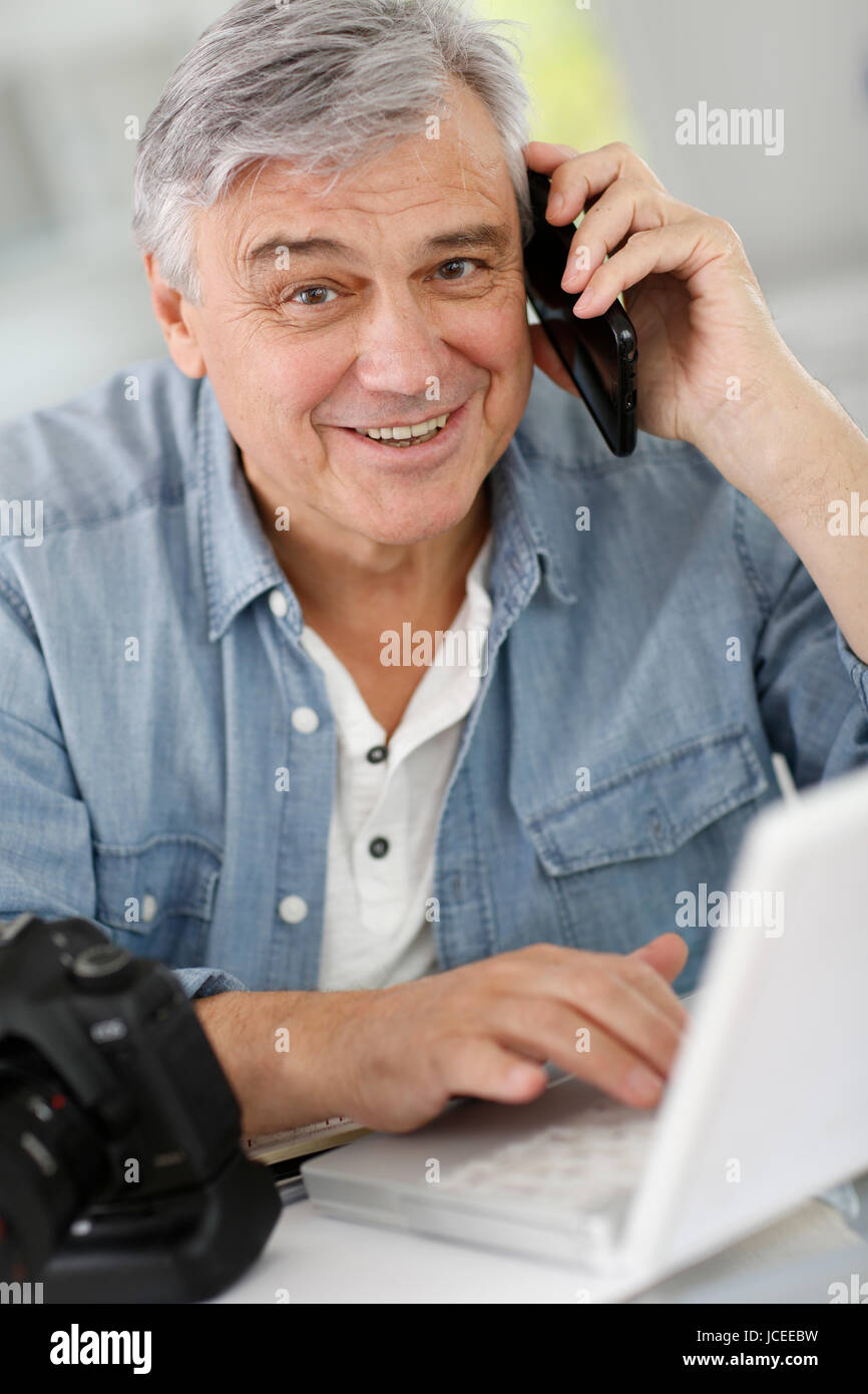 Photographer in office talking to client on the phone Stock Photo - Alamy