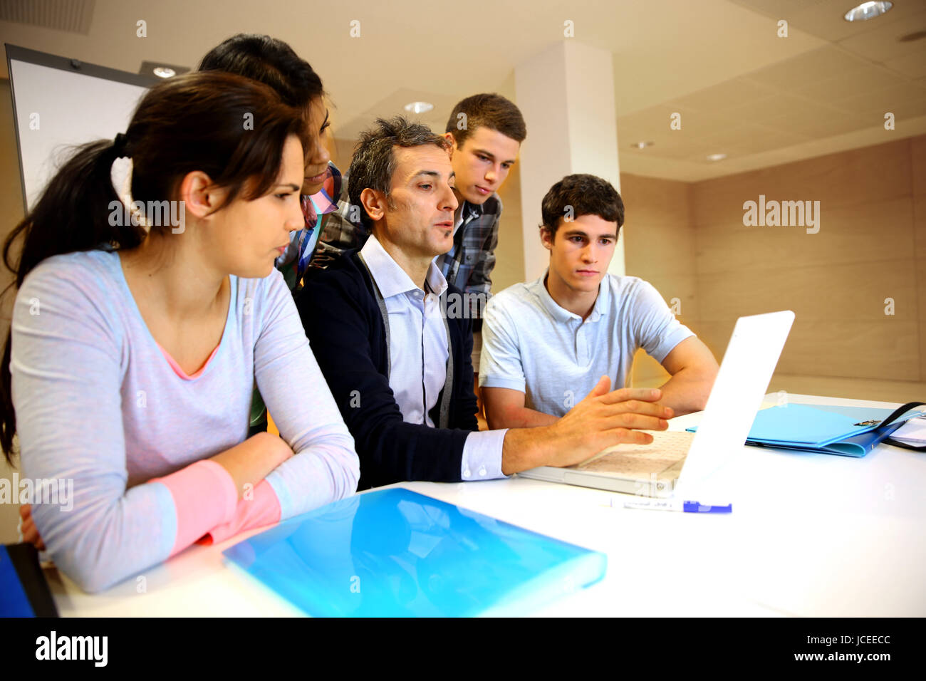 Teacher with students in class working on laptop Stock Photo - Alamy