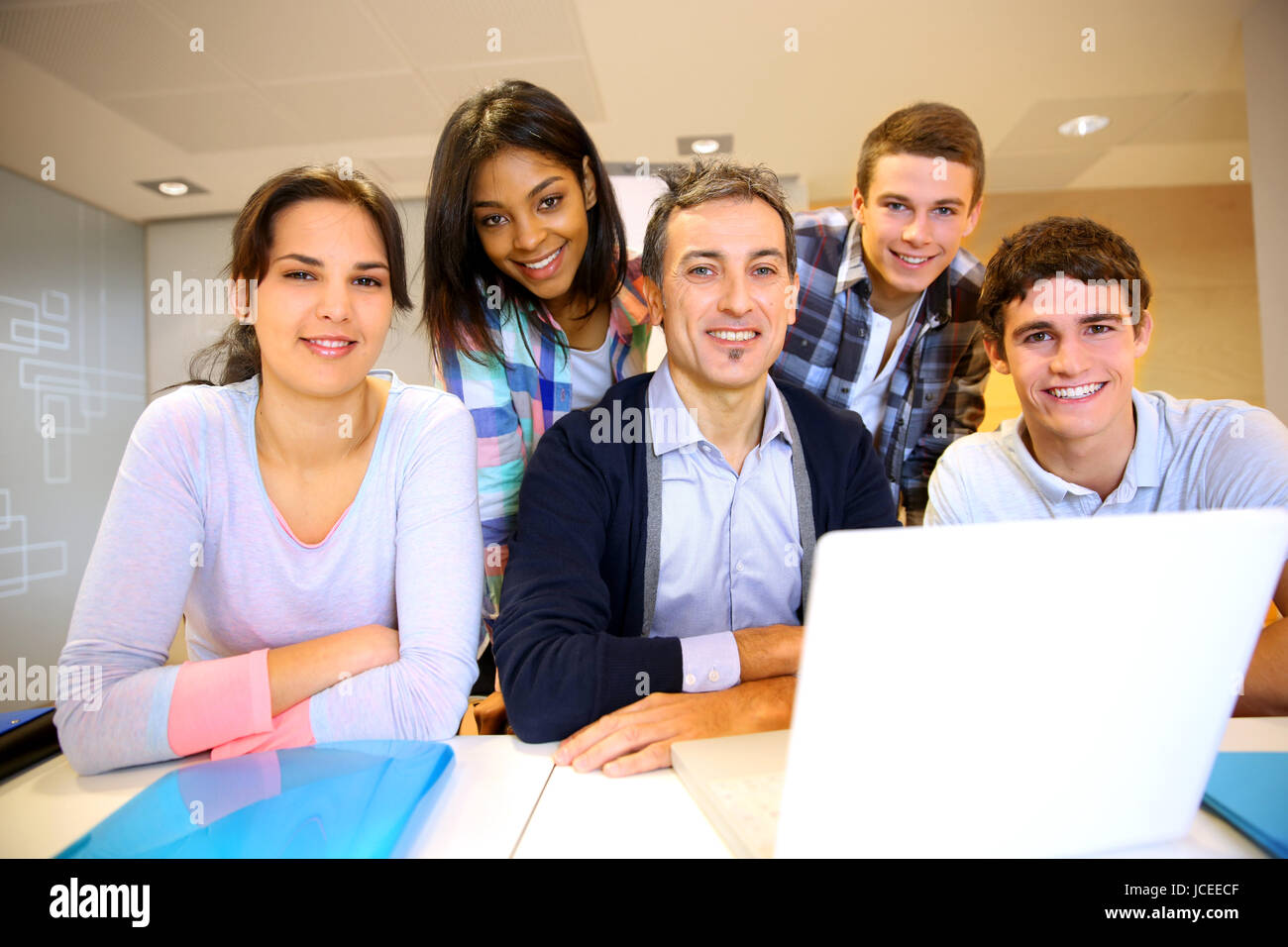 Teacher with students in class working on laptop Stock Photo - Alamy