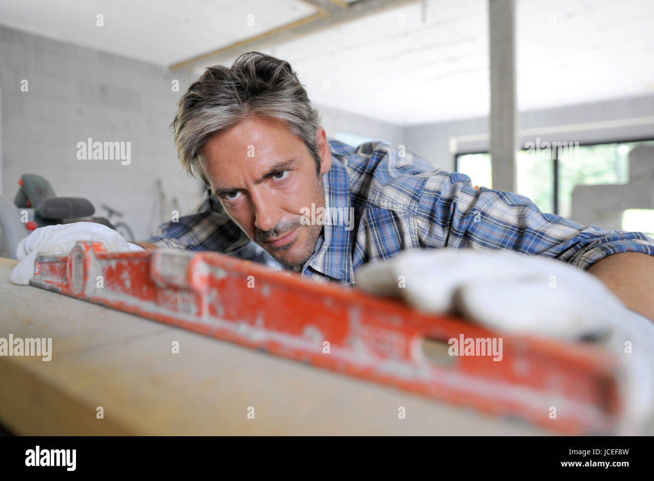 Man using level inside house under construction Stock Photo - Alamy