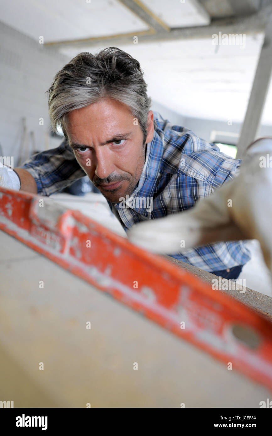 Man using level inside house under construction Stock Photo - Alamy