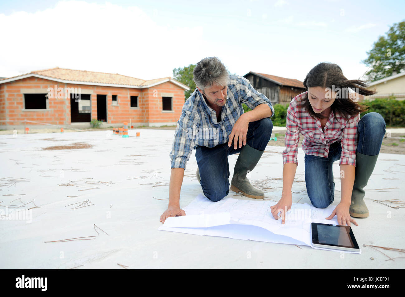 Couple checking construction plan on site Stock Photo - Alamy